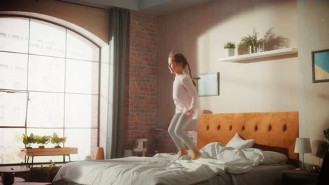 Small Girl Jumping on Bed | Stock Video | Pond5