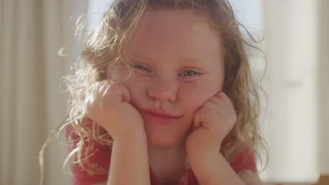 Small Girl Resting Face in Hands While S... | Stock Video | Pond5