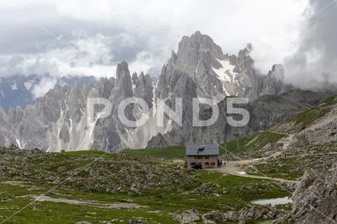 Small stone hut with jagged mountain range in the background Stock ...