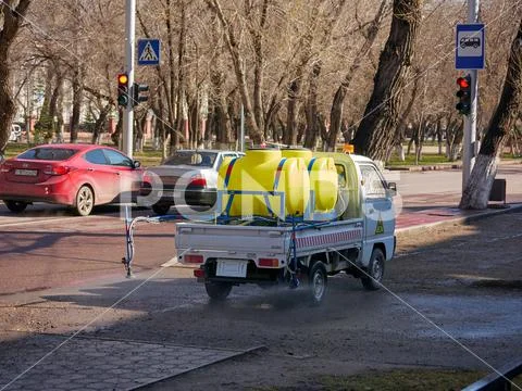A small truck with a biohazard sign on board disinfects city streets to ...