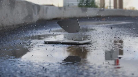 Smart cell phone drop in puddle on stree... | Stock Video | Pond5