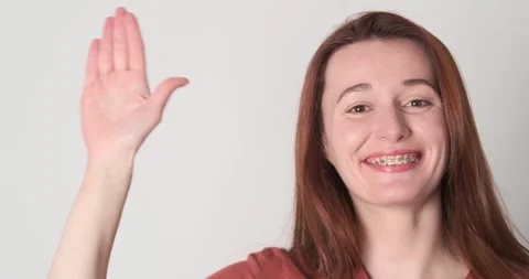 Smile and wave. Young woman waving hand ... | Stock Video | Pond5
