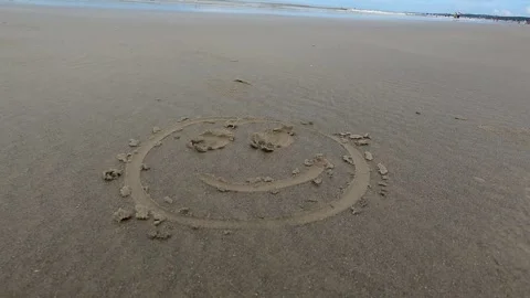 Smiley Face Drawn in the Sand | Stock Video | Pond5