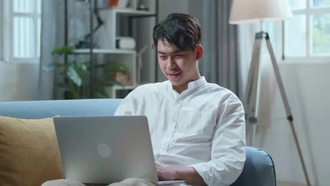 Smiling Asian Man Typing On Laptop Compu... | Stock Video | Pond5