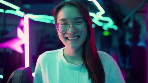 Smiling Asian woman gamer looking at cam... | Stock Video | Pond5