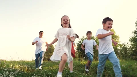 Smiling children with parents run across... | Stock Video | Pond5