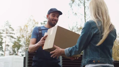 Smiling Delivery Man Hands Over Parcel a... | Stock Video | Pond5