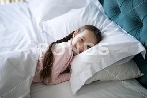 Smiling girl lying on bed in bedroom ~ Premium Photo #78442434