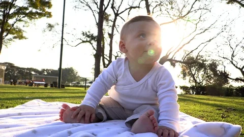 Smiling happy baby child seated at outdo... | Stock Video | Pond5