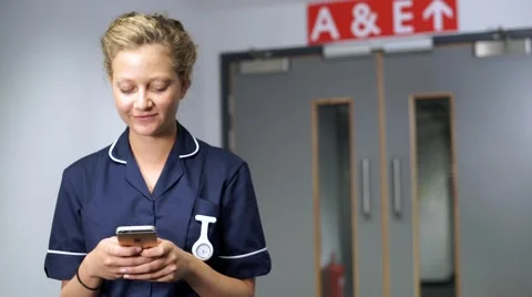 Smiling nurse using cell mobile phone in... | Stock Video | Pond5