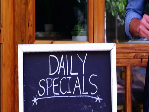 Smiling waiter standing with menu and op... | Stock Video | Pond5