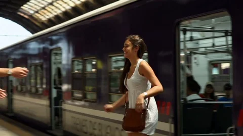 Smiling young woman steps off a train in... | Stock Video | Pond5