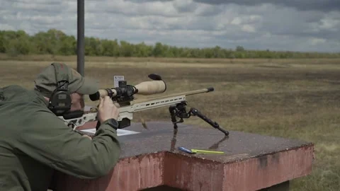 A sniper shoots a rifle with a sight in ... | Stock Video | Pond5