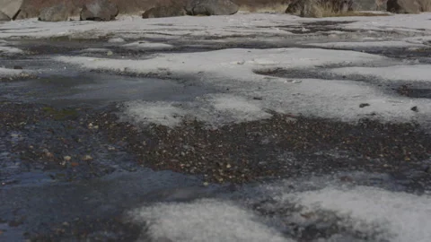 Snow Melt Slowly Flowing on a Gravel Sur... | Stock Video | Pond5