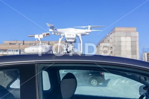 Snow white quadrocopter and remote control on the roof of car ~ Hi Res ...