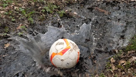 Soccer ball/football splashing in a mudd... | Stock Video | Pond5