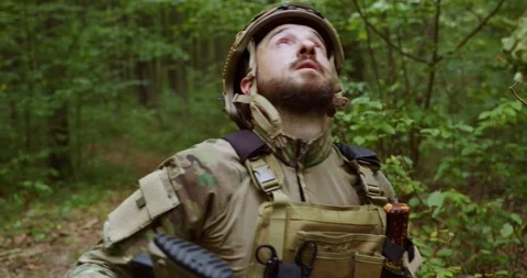 the soldier falls to his knees and looks... | Stock Video | Pond5