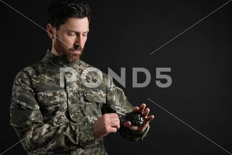 Soldier pulling safety pin out of hand grenade on black background ...