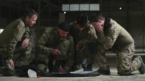 Soldiers kneeling around map and using l... | Stock Video | Pond5
