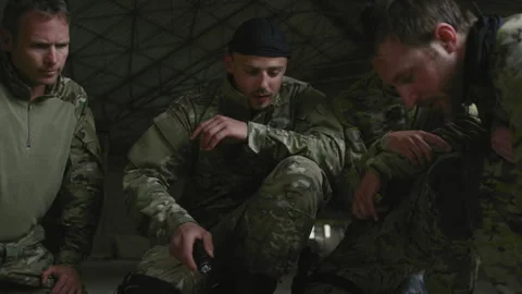 Soldiers kneeling around map on floor in... | Stock Video | Pond5