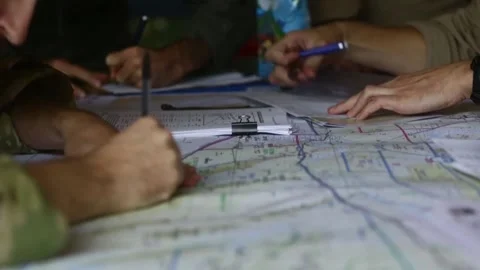 Soldiers marking locations on map | Stock Video | Pond5