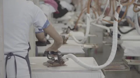 Some factory employees are ironing cloth... | Stock Video | Pond5
