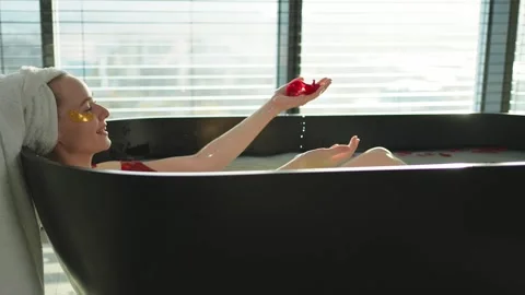 Spa relaxation. Woman lying in bath with... | Stock Video | Pond5