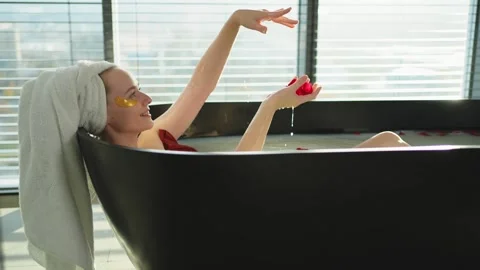 Spa relaxation. Woman lying in bath with... | Stock Video | Pond5