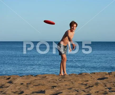 Spanish attractive male playing frisbee on the sea background ...