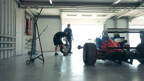 Specialists are fixing wheels of a racin... | Stock Video | Pond5