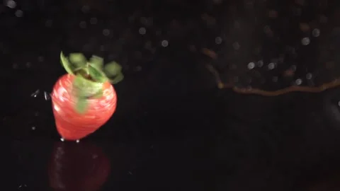 Spinning Strawberry in Water on a Black ... | Stock Video | Pond5