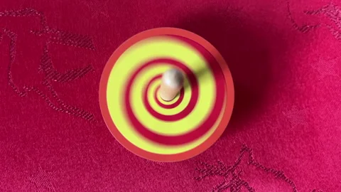Spinning top on table with red cloth | Stock Video | Pond5