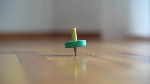A spinning top on a wooden floor. Rotati... | Stock Video | Pond5