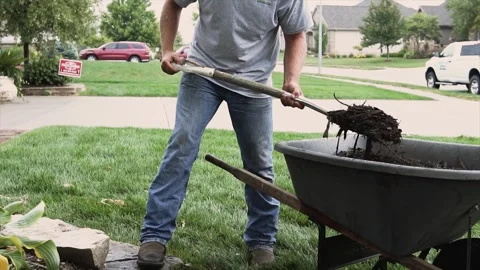 Spreading mulch from wheel barrel | Stock Video | Pond5
