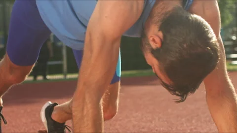 Sprinter taking a crouching position and... | Stock Video | Pond5