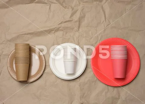Stack of paper cups and round plates on a brown paper background ~ Hi ...