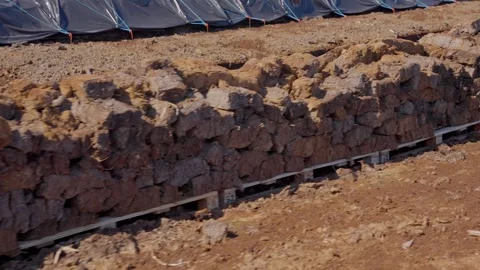 Stacked peat blocks drying outdoors on p... | Stock Video | Pond5