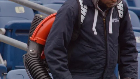 Stadium staff cleaning seats with blower | Stock Video | Pond5