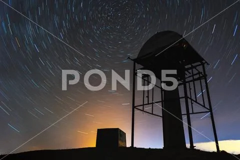 Star tracks in the night sky behind the meteorological autonomous tower ...
