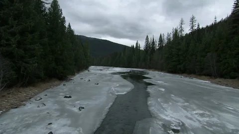 Static shot of frozen river flowing in f... | Stock Video | Pond5