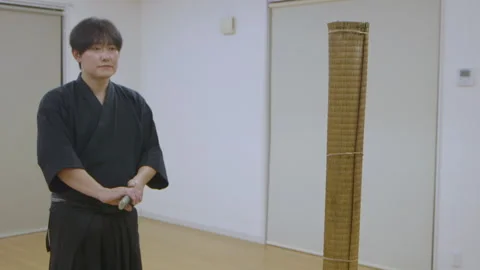 Static shot of samurai in a gym cutting ... | Stock Video | Pond5