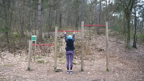 Static shot of women doing pull-ups on a... | Stock Video | Pond5