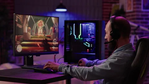 Static tripod shot of man using pc setup... | Stock Video | Pond5