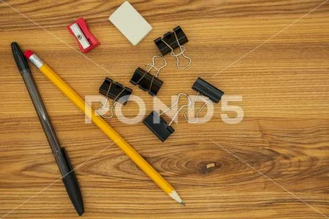 Stationery set. Pencil, pen, scraper, eraser and black paper clips ...