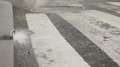Steam from manhole at crosswalk with pud... | Stock Video | Pond5