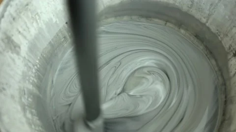 Stirs gray paint in a bucket. Painting w... | Stock Video | Pond5