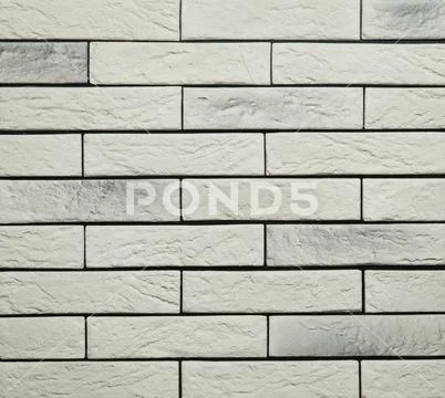 Stone cladding wall made of striped stacked slabs of white and grey ...