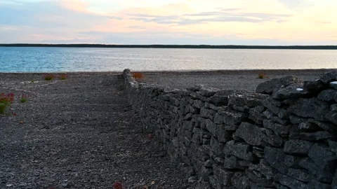 Stone wall on cobblestone beach with oce... | Stock Video | Pond5