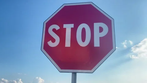 Stop signal with cloudy blue sky in back... | Stock Video | Pond5