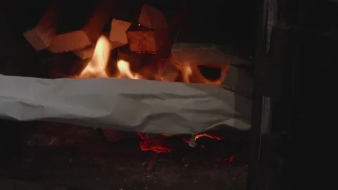 In the stove, burning paper is brought t... | Stock Video | Pond5